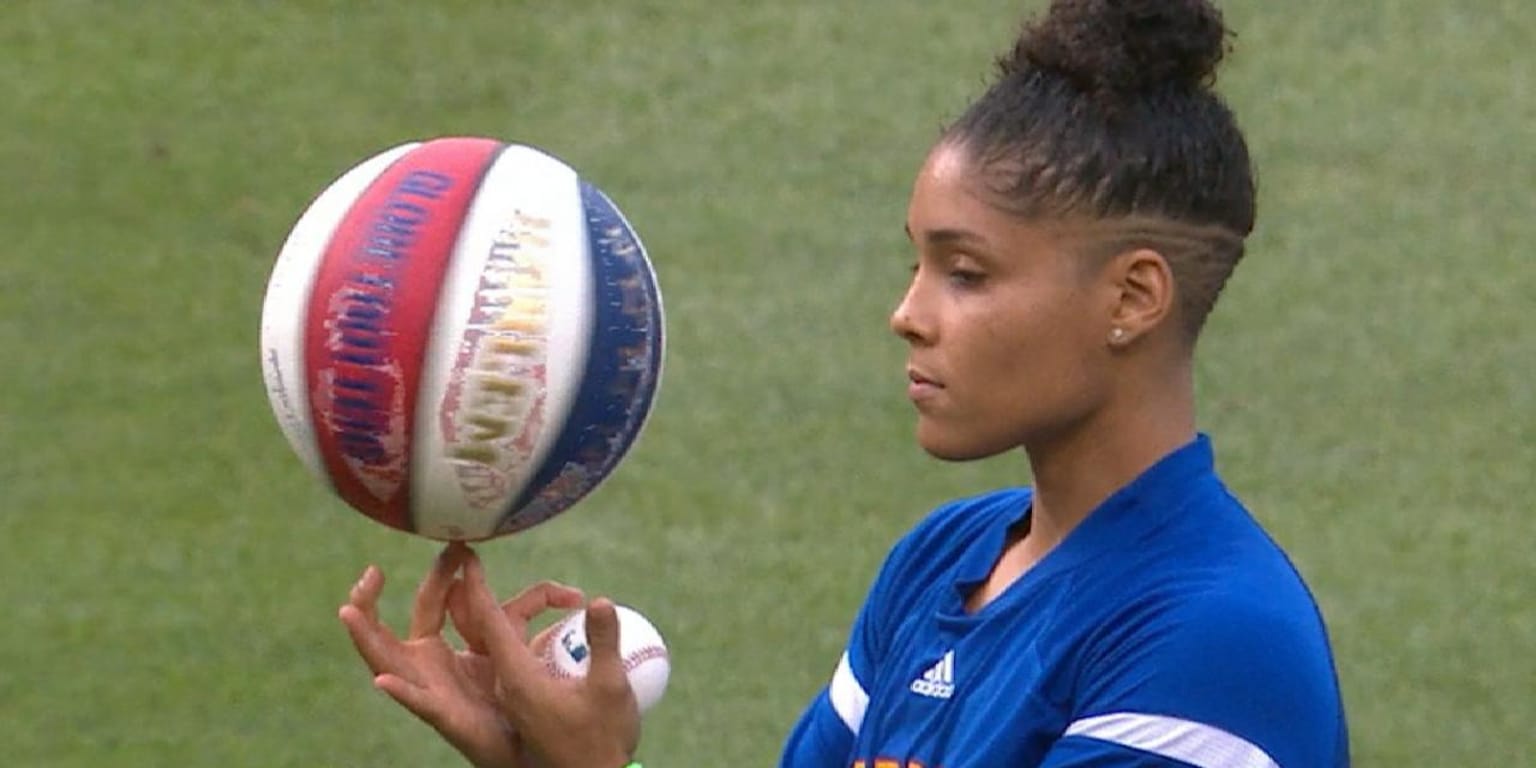 Ace Jackson of the Harlem Globetrotters threw a pitch while spinning a ...
