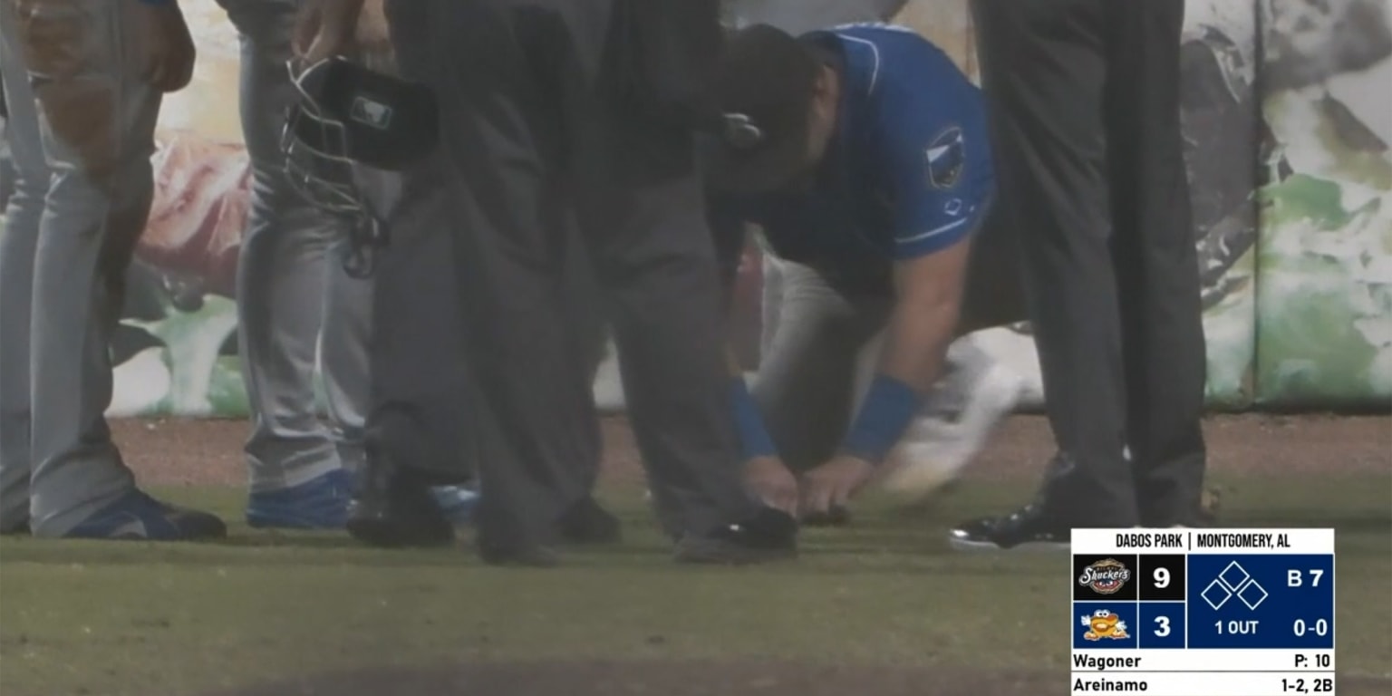 Baseball gets stuck in outfield grass when outfielder slides on it